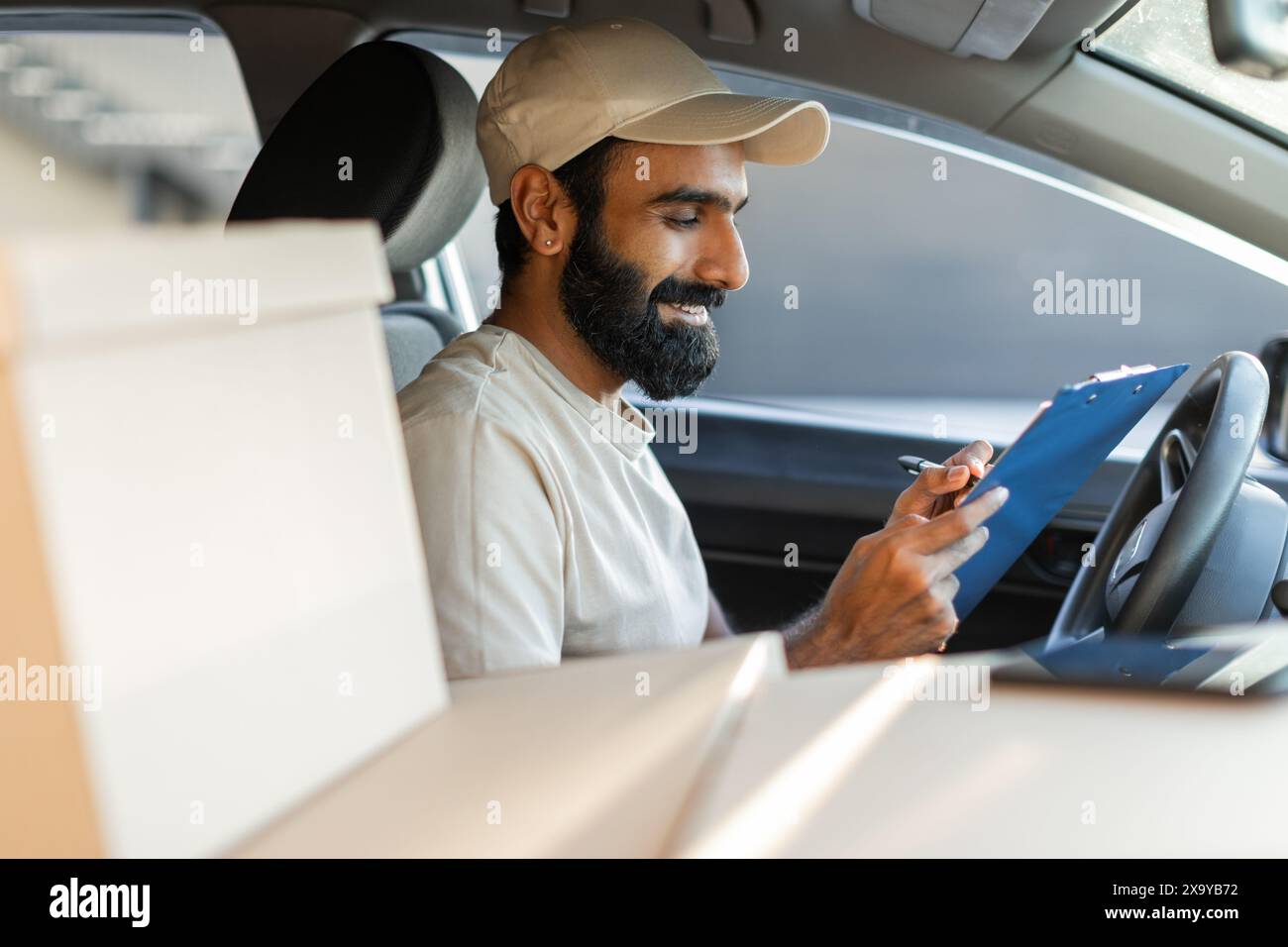Courier Checking Delivery List Inside Vehicle During Daytime Stock ...