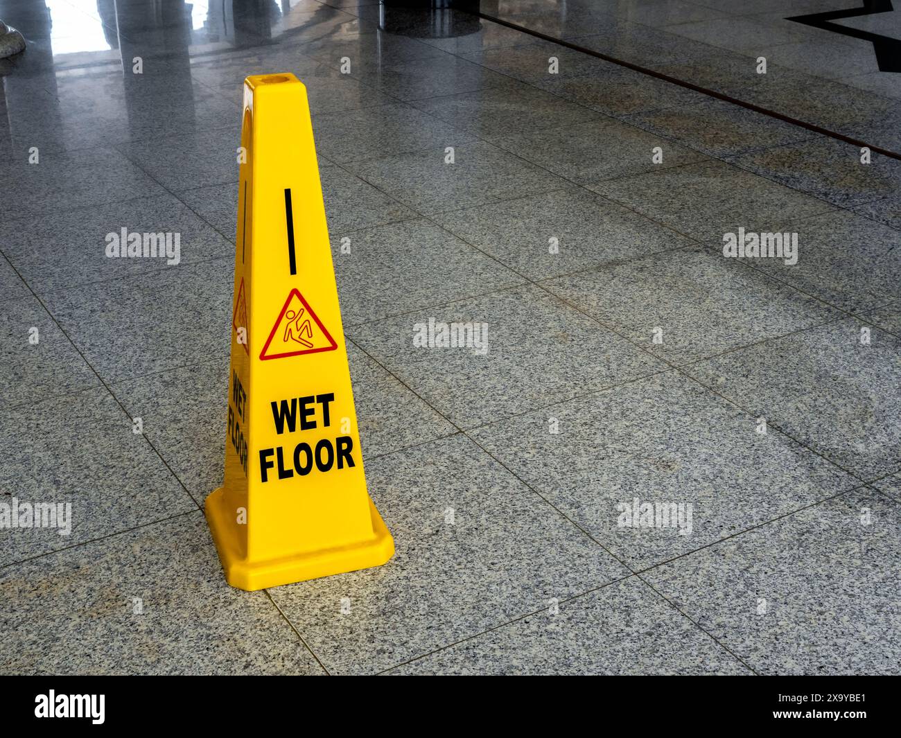 Wet floor caution sign on walkway in modern building. Warning red slip ...