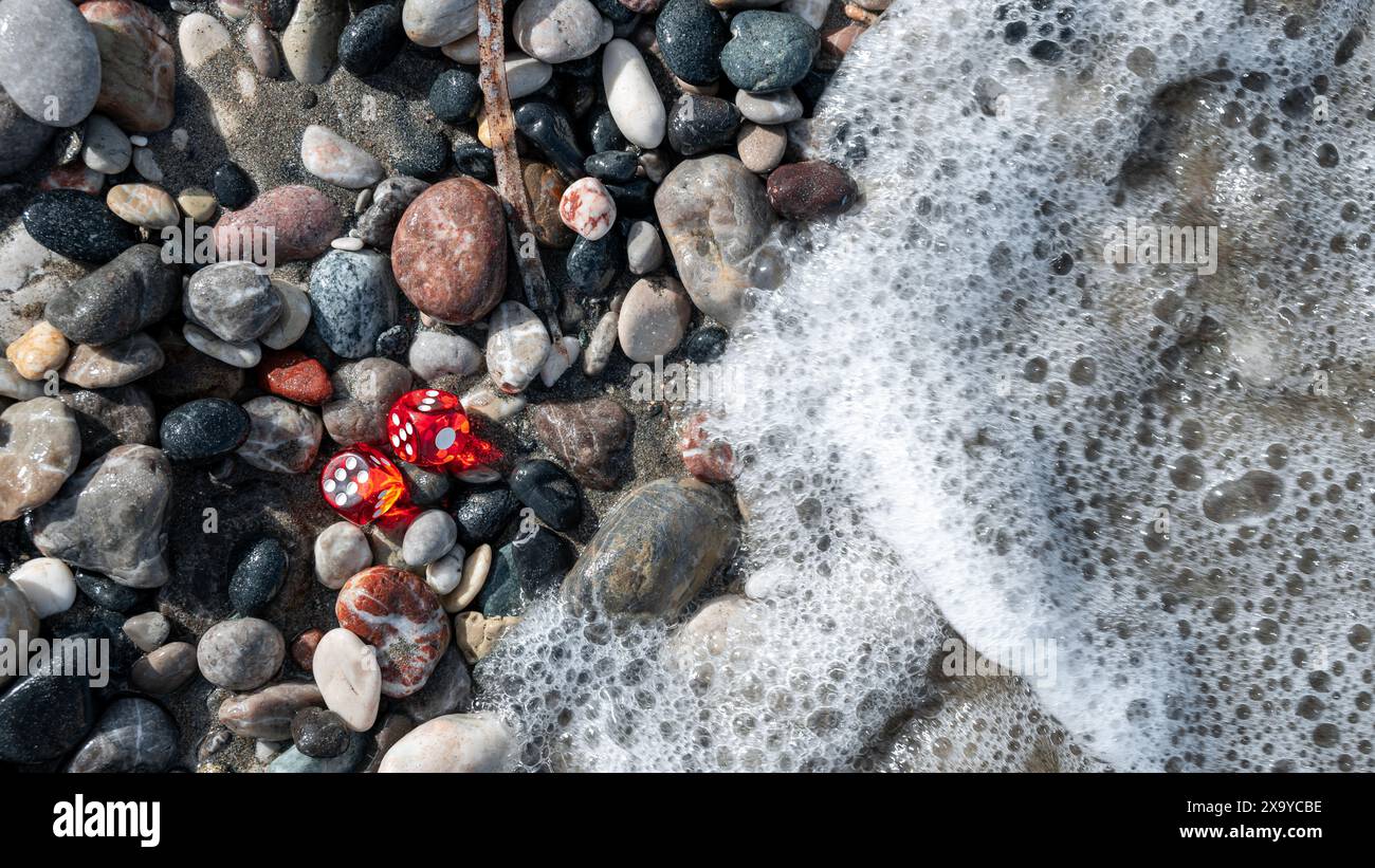 Red playing dice among gray stones and foam from the sea wave Stock ...