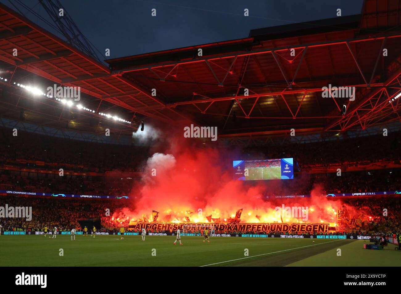 Borussia Dortmund fans light smoke flares as they display a banner ...