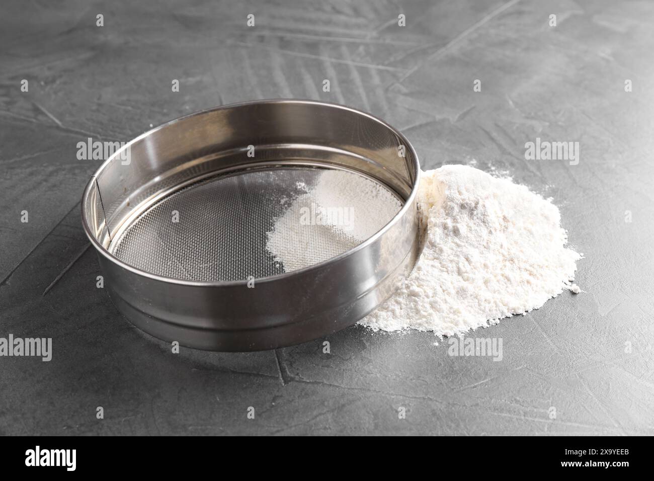 Metal sieve and flour on grey table Stock Photo - Alamy