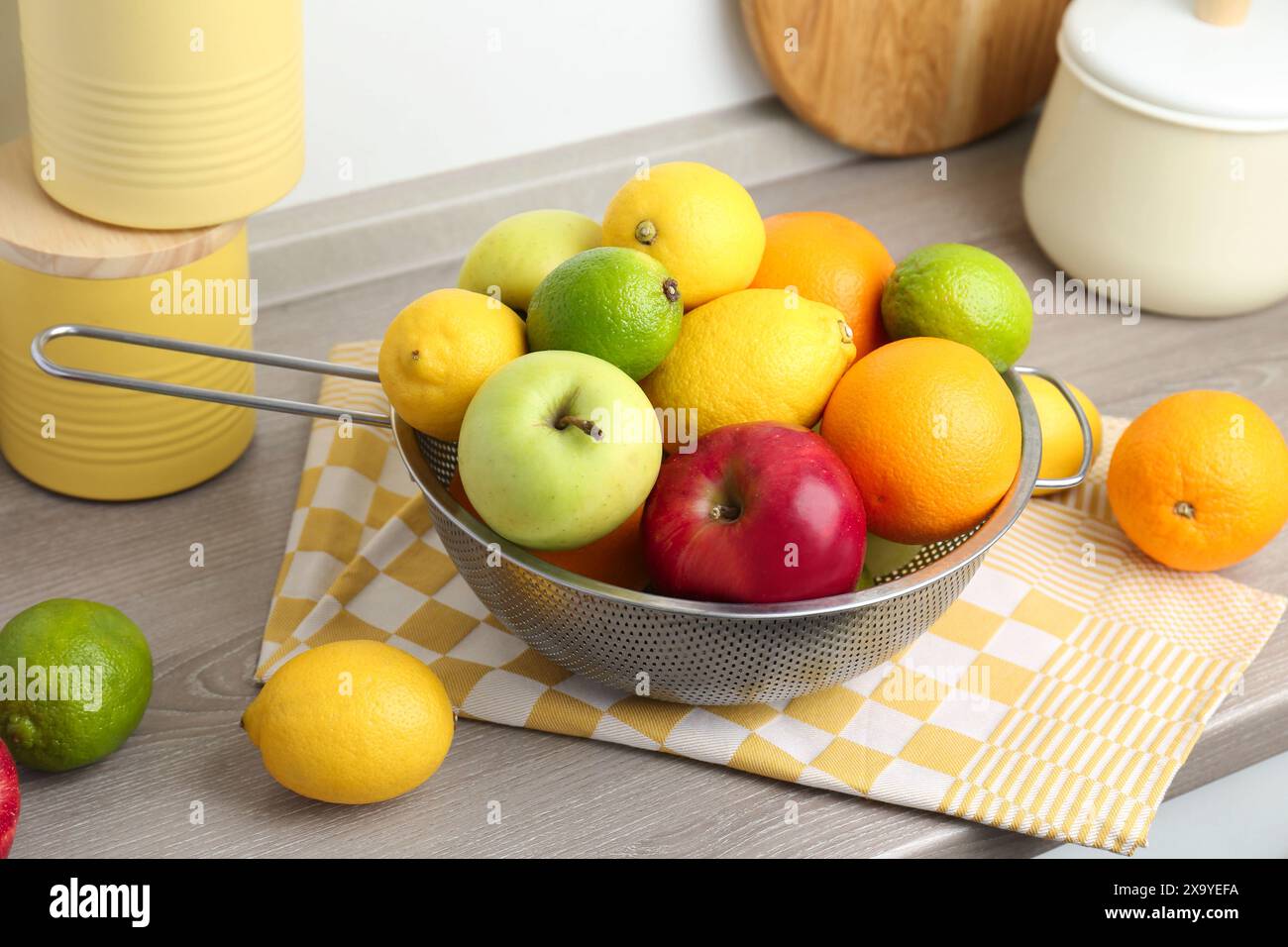 Metal colander with different fruits on countertop in kitchen Stock ...