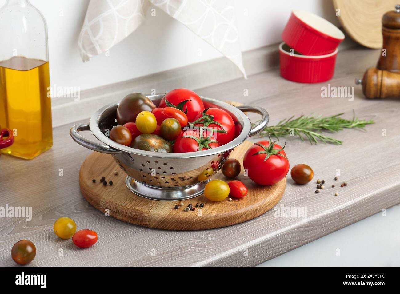 Metal colander with tomatoes on countertop in kitchen Stock Photo - Alamy