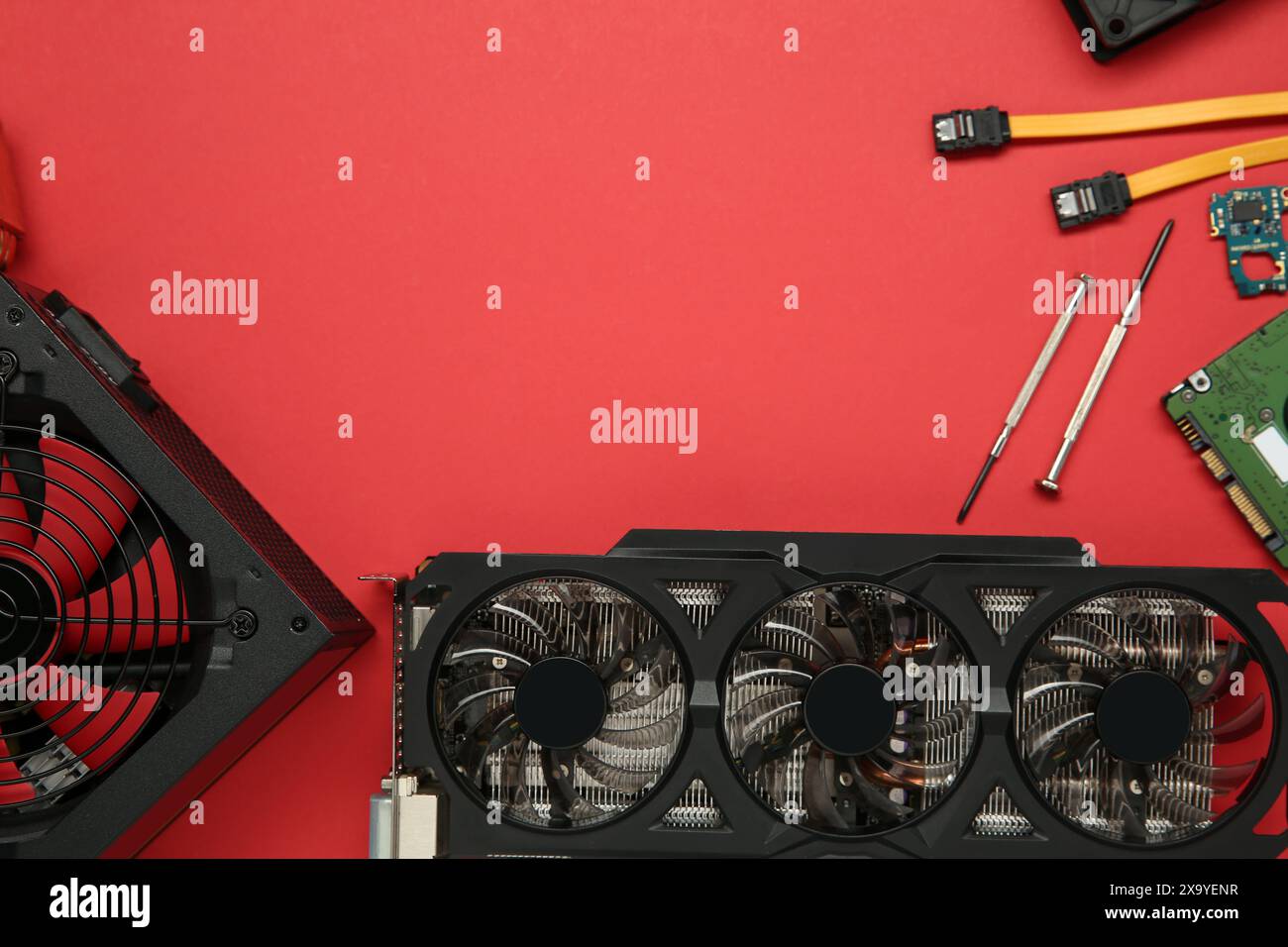 Graphics card and other computer hardware on red background, flat lay ...