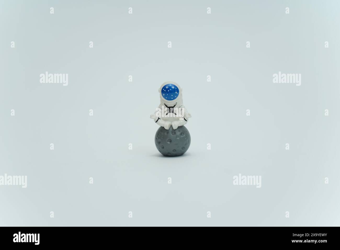 An Astronaut sitting meditating on a planet, on a white background, the ...