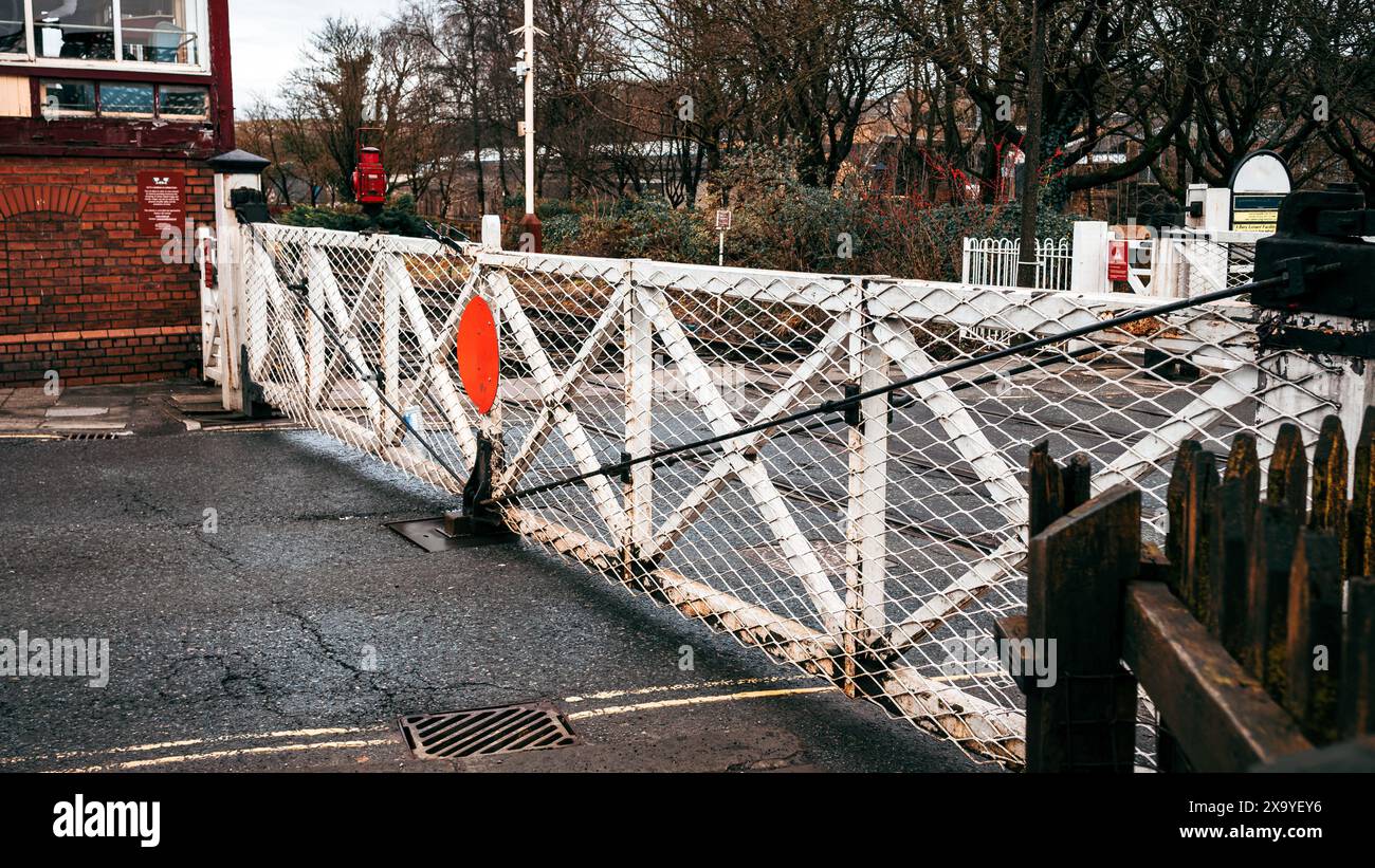 Railway level crossing with gates across the road Stock Photo - Alamy