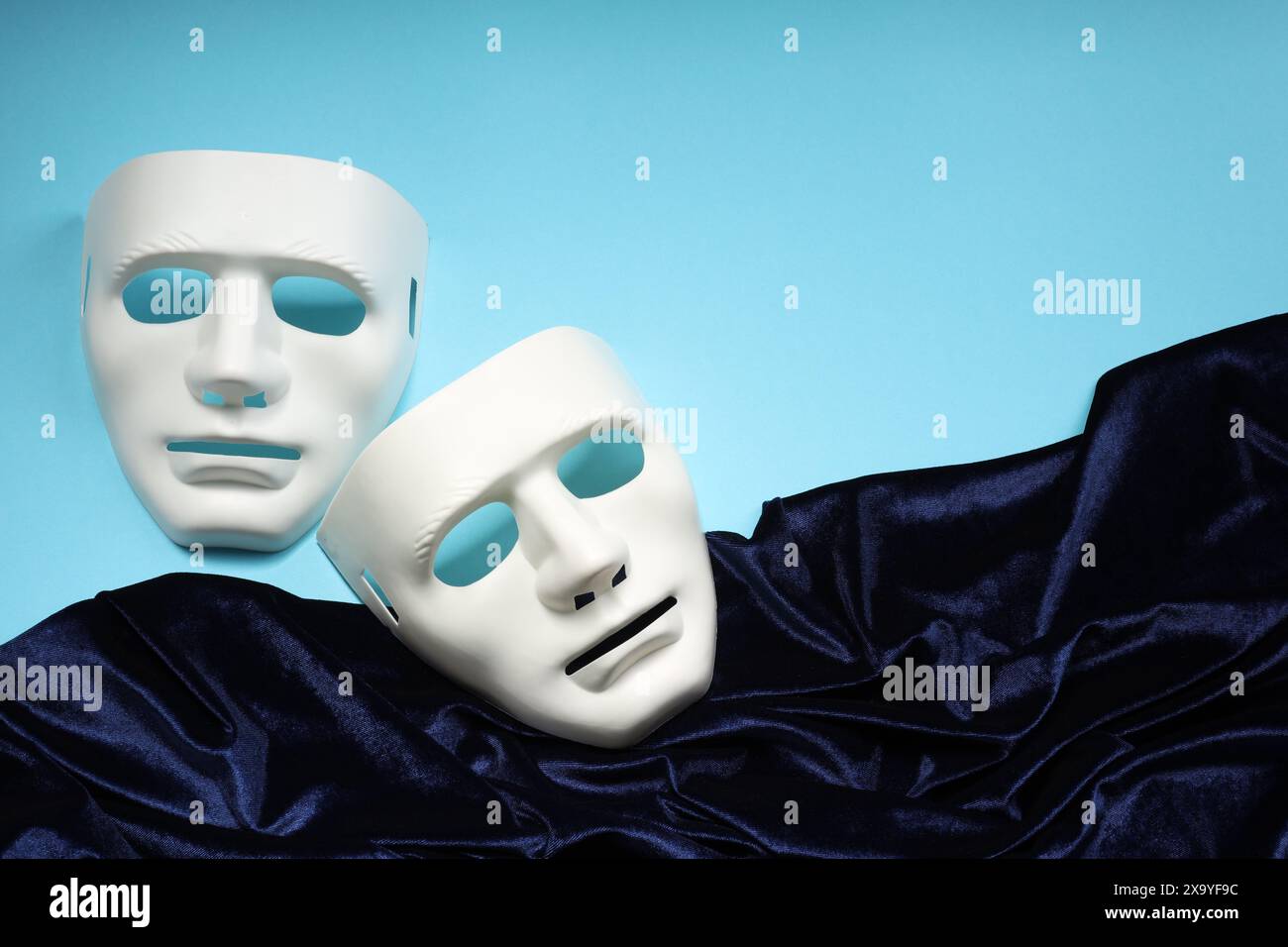 Theater arts. White masks and fabric on light blue background, above ...