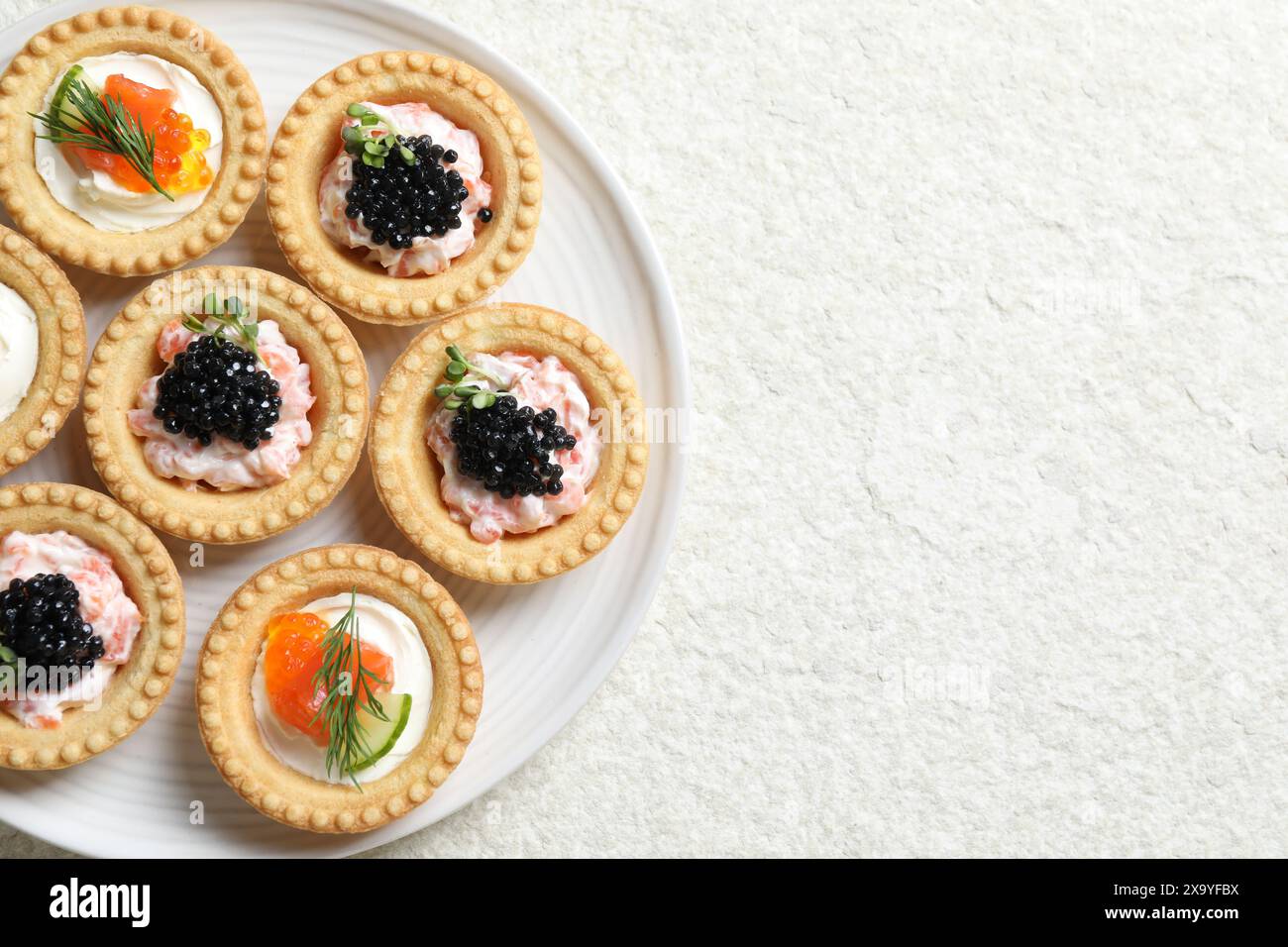 Delicious canapes with salmon and caviar on beige textured table, top ...