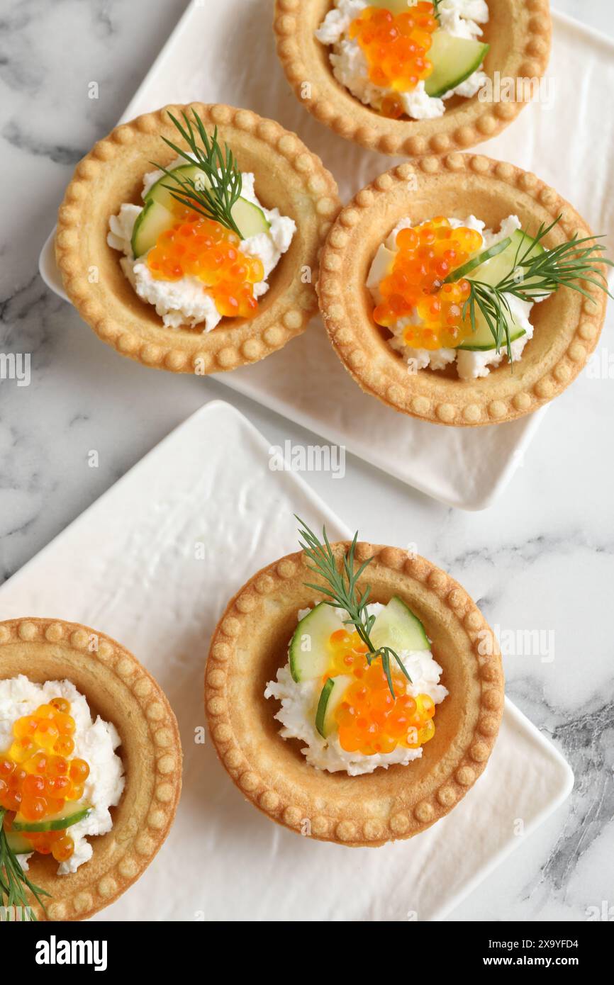 Delicious canapes with red caviar on white marble table, top view Stock ...
