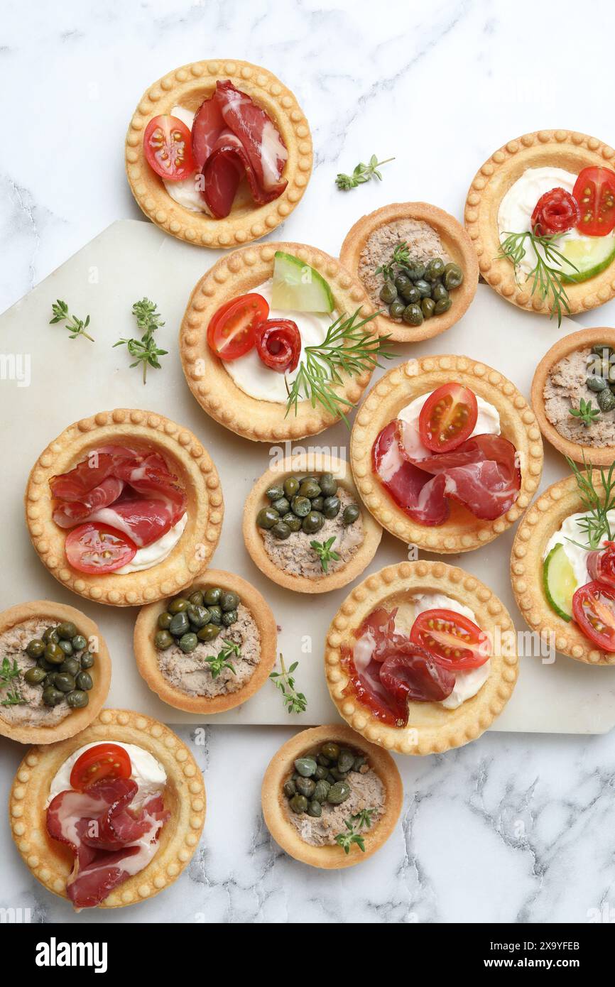 Different delicious canapes on white marble table, flat lay Stock Photo ...