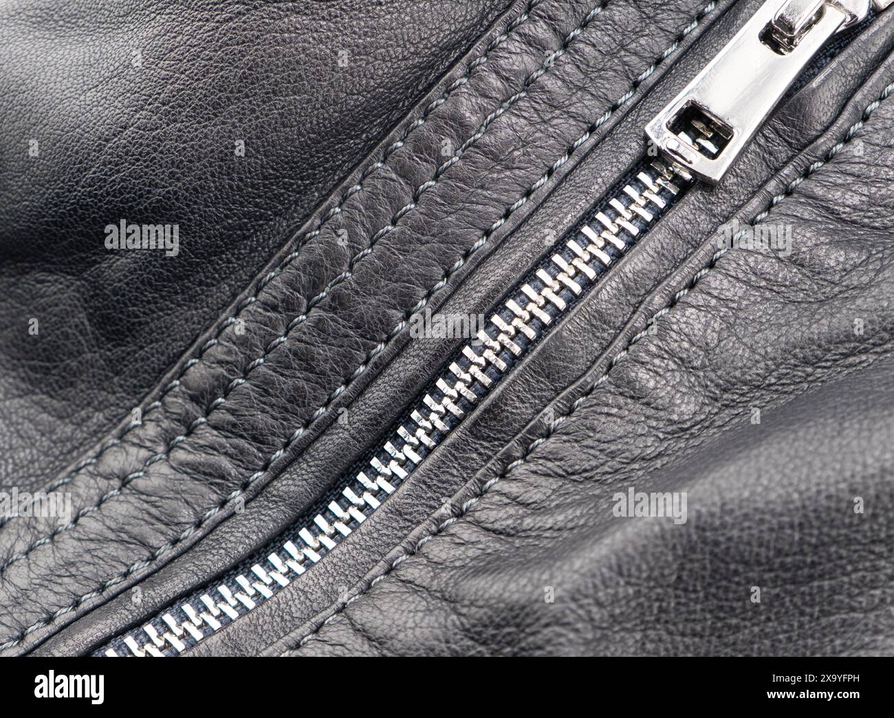 Macro shot of zipper on black leather texture background with stitching ...