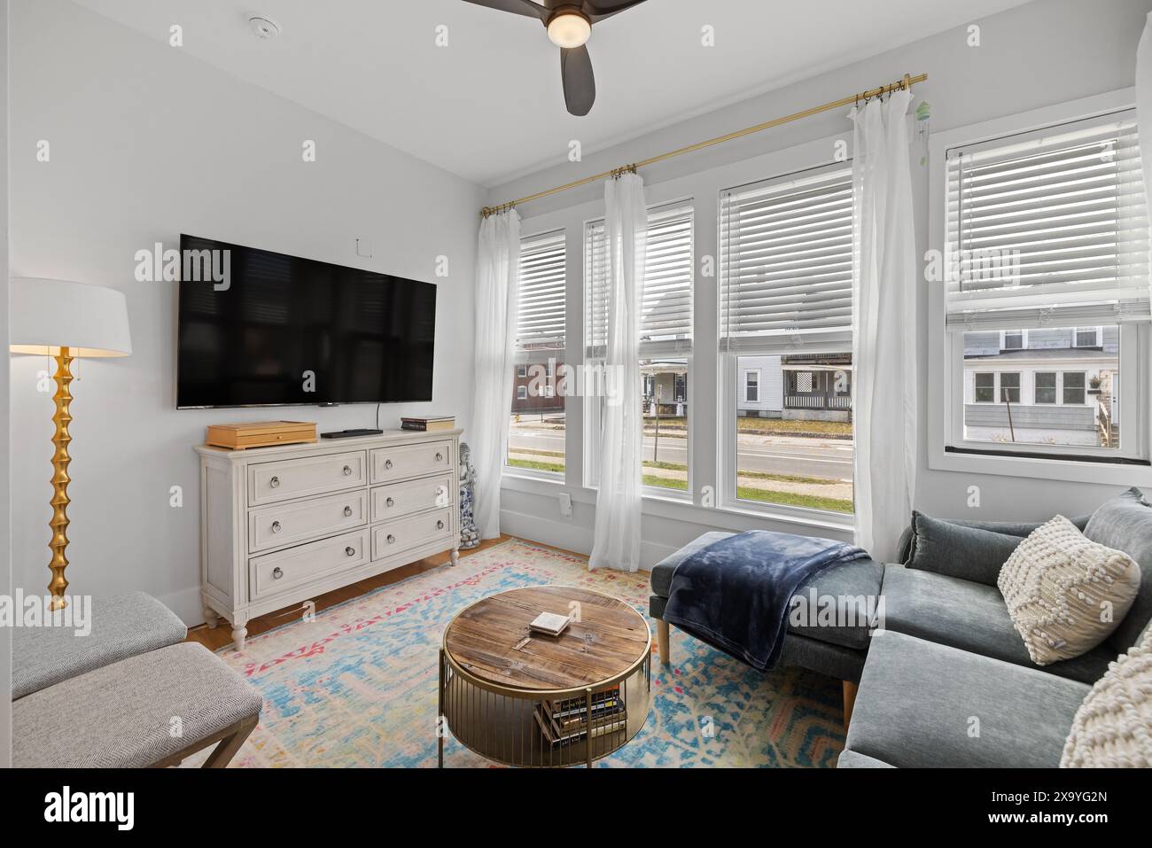 A living room with windows and a big screen TV Stock Photo - Alamy