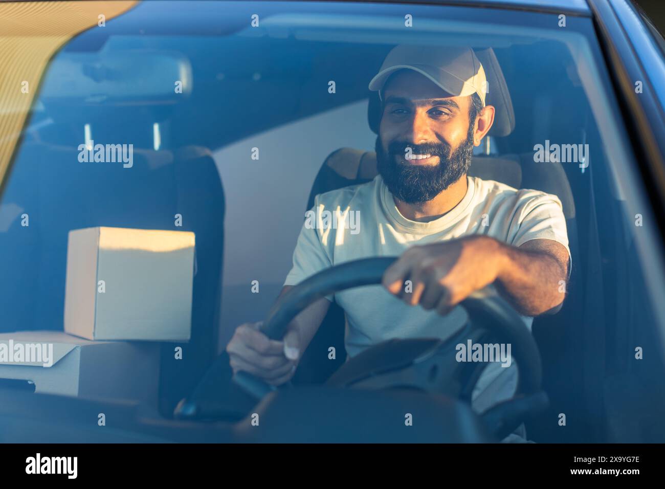 Smiling Delivery Driver Navigates Urban Streets in the Early Morning ...