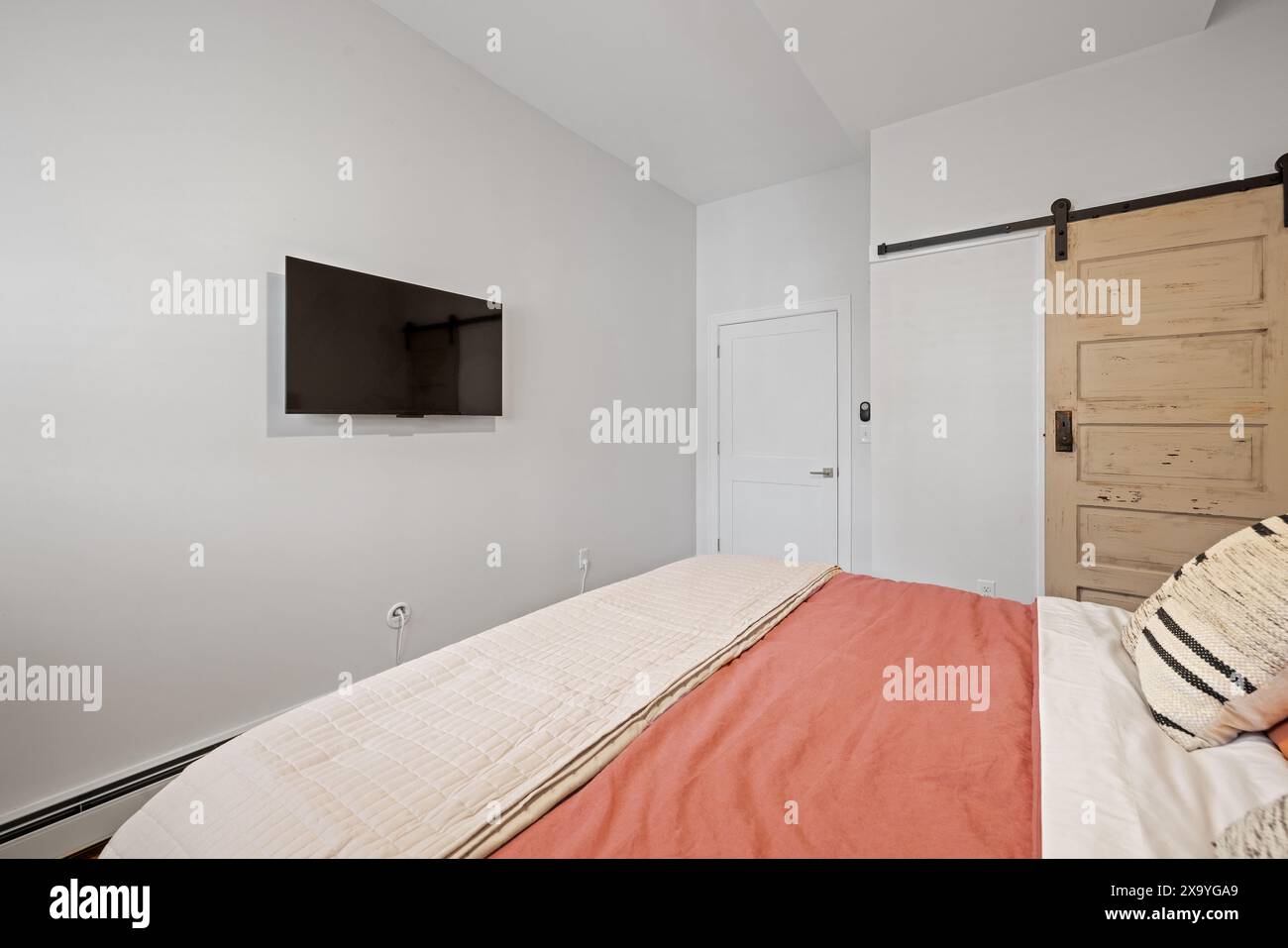 Modern bedroom with wall-mounted flat screen TV Stock Photo - Alamy