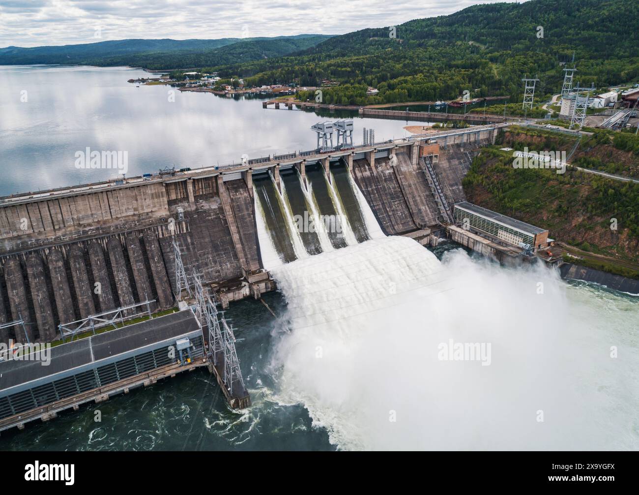 Aerial view of concrete dam releasing water into river on cloudy day ...