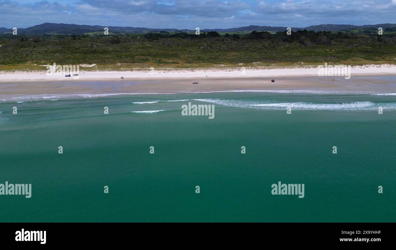 An aerial view of Uretiti Beach surrounded by green waters. New Zealand ...