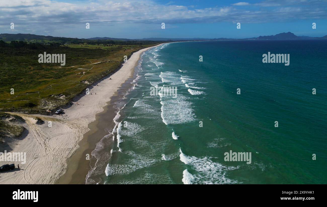 An aerial view of Uretiti Beach surrounded by green waters. New Zealand ...