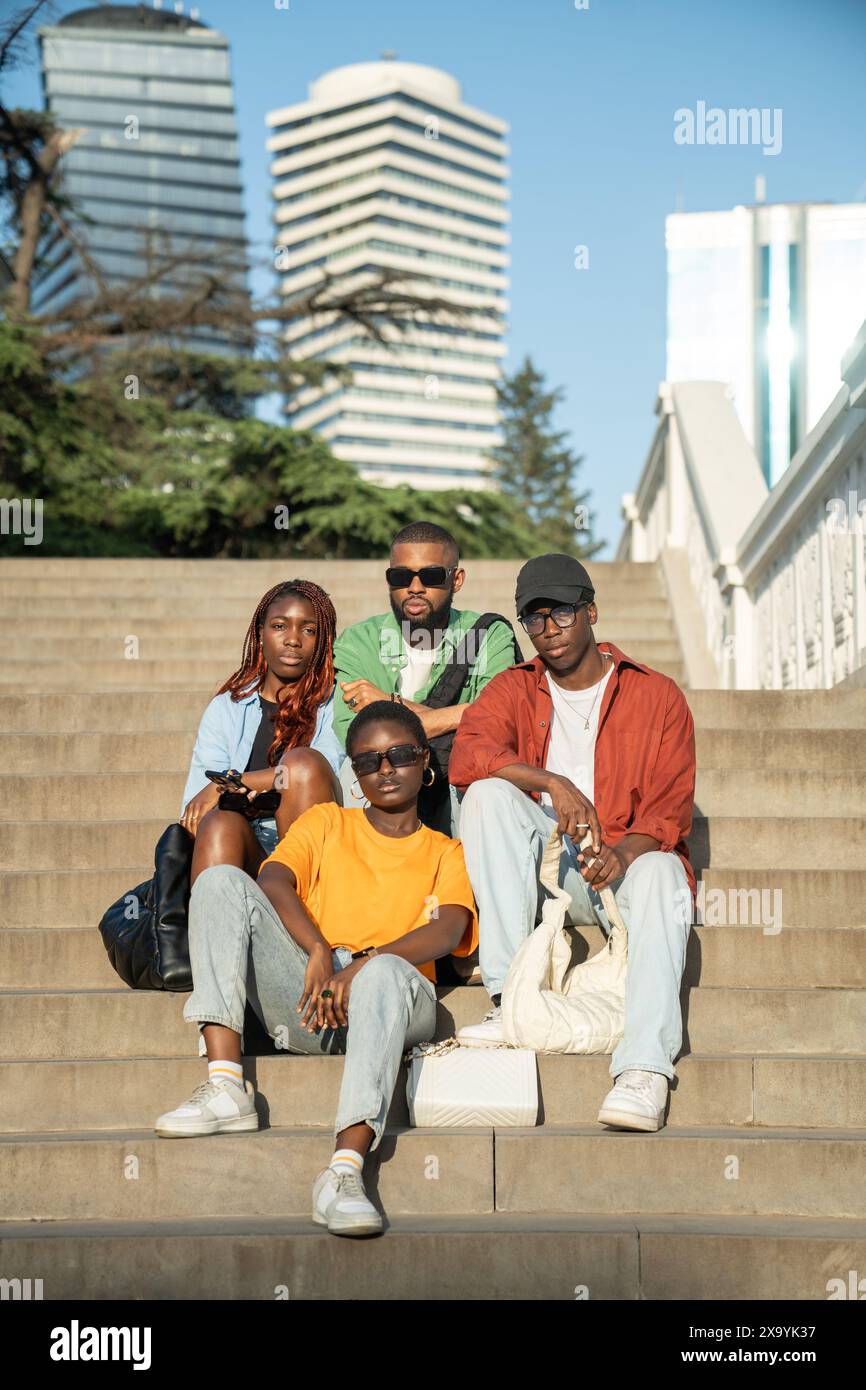 Focused serious group of african american students sitting on stairs in ...