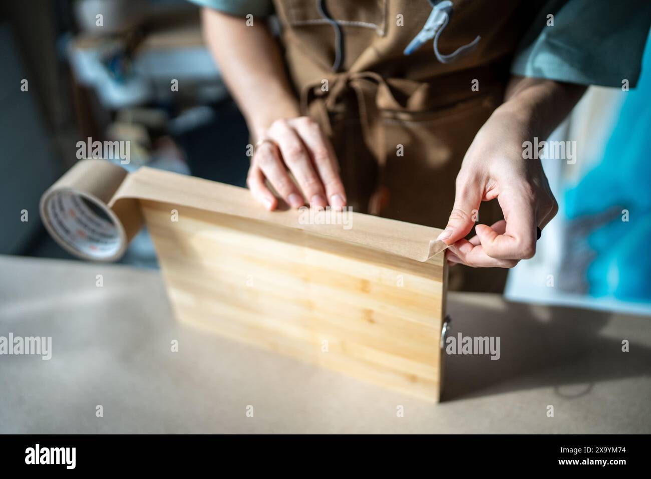 Palms of careful female artist taping edges of wooden canvas board for ...