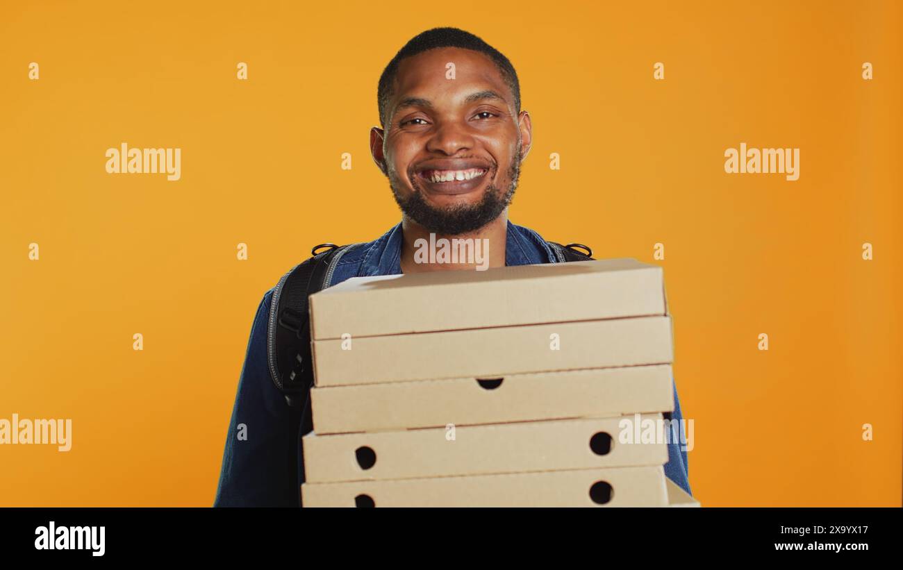 African american pizzeria deliveryman holding stack of pizza boxes to ...