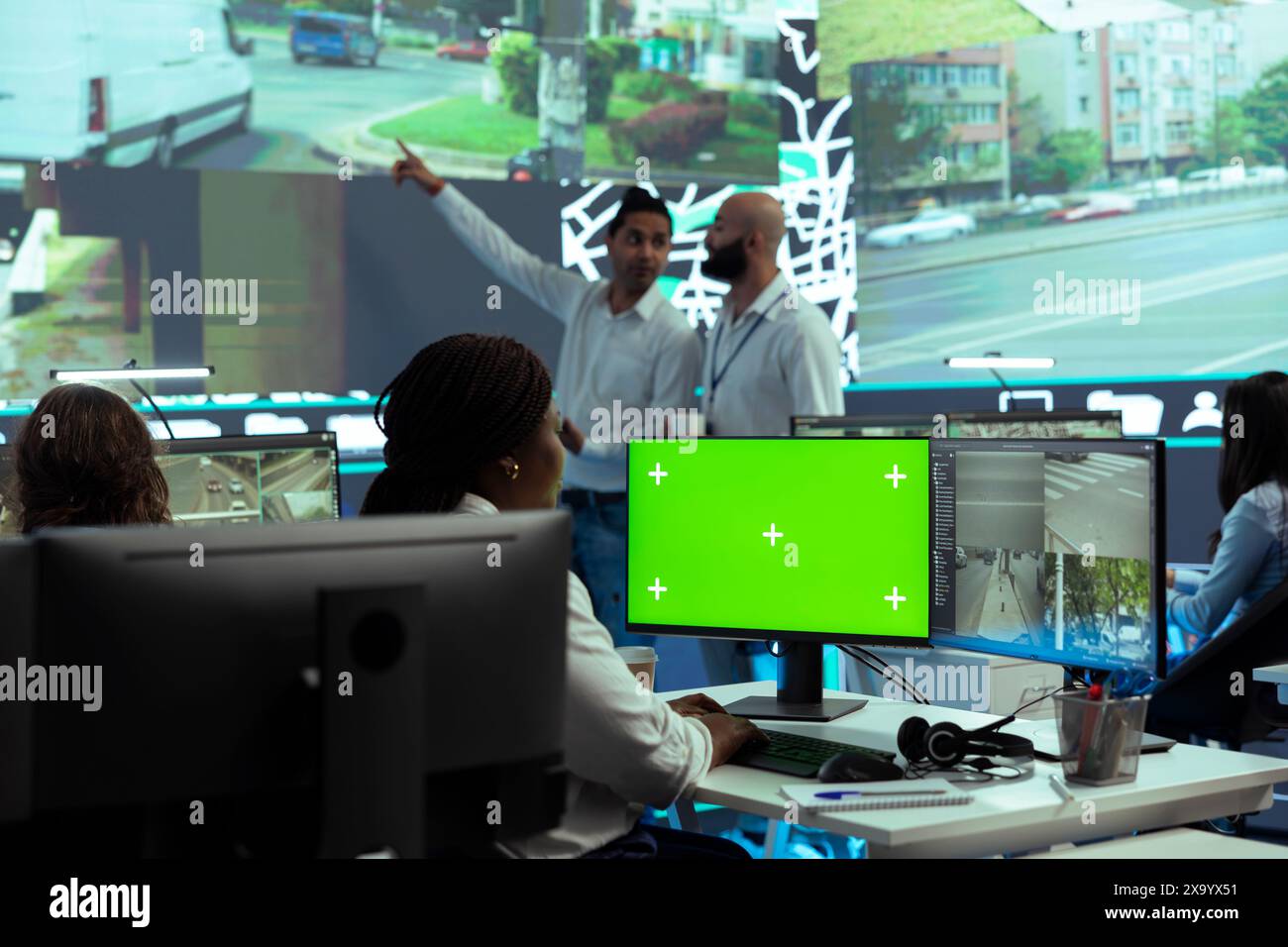 African american employee monitoring delivery trucks on CCTV cameras ...