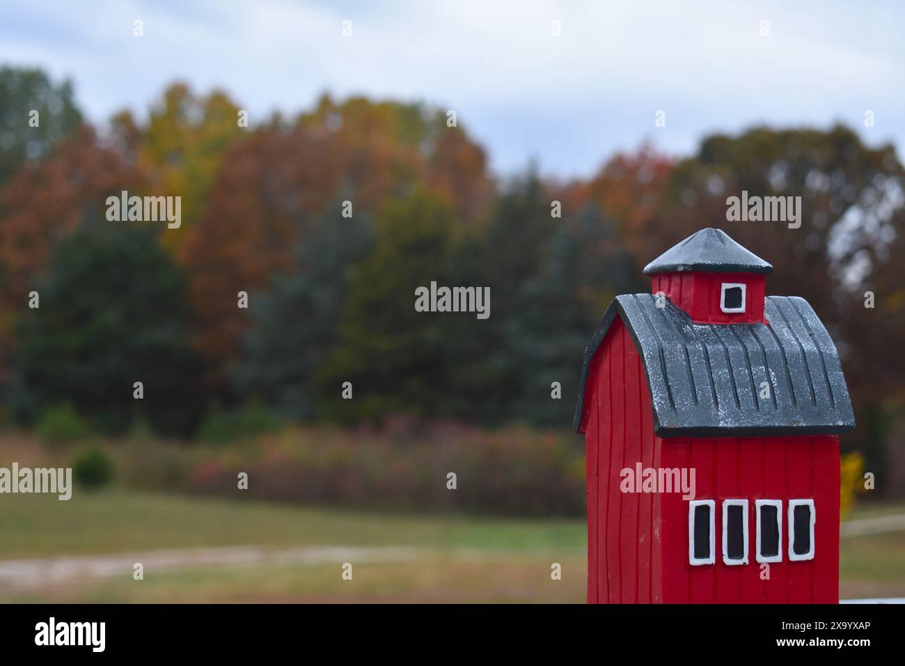Red Barn Birdhouse Against a Fall Background, with copy or text space ...