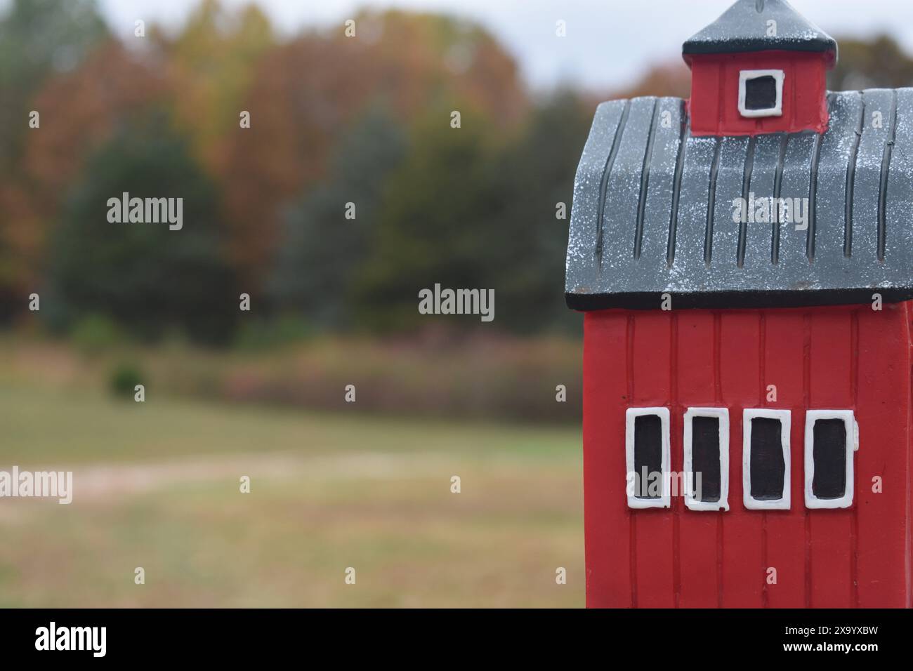 Red Barn Birdhouse Against a Fall Background, with copy or text space ...