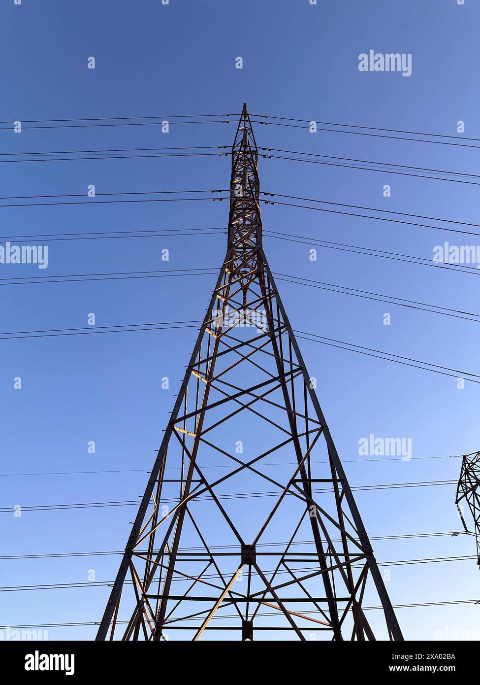 A utility tower standing tall under a clear blue sky Stock Photo - Alamy