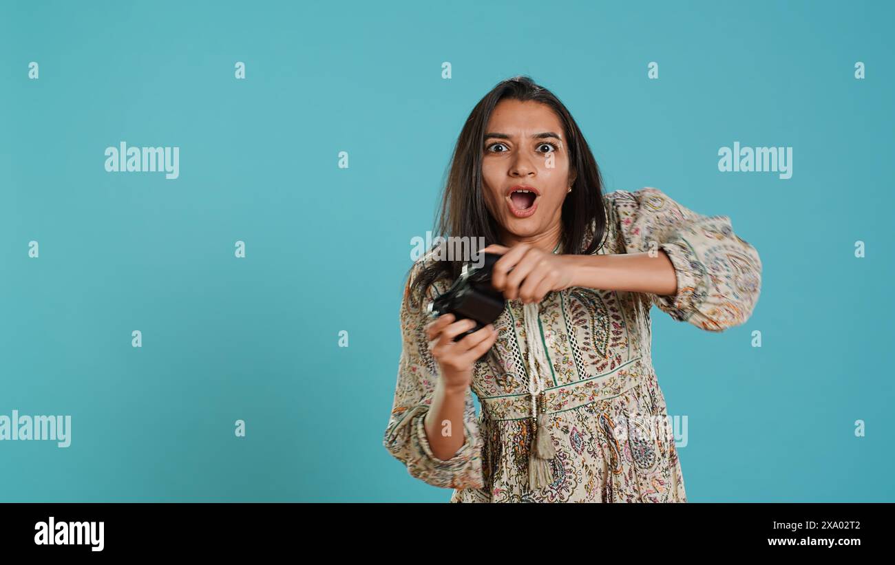 Competitive woman playing videogames with motion controlled controller ...