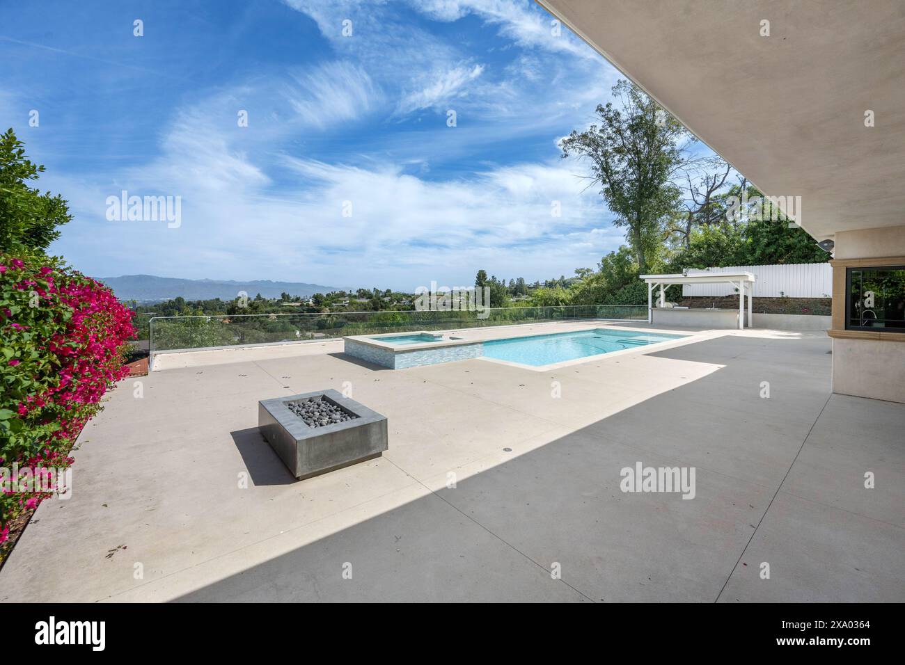 An outdoor pool with concrete tables and tall skyscraper in Encino ...