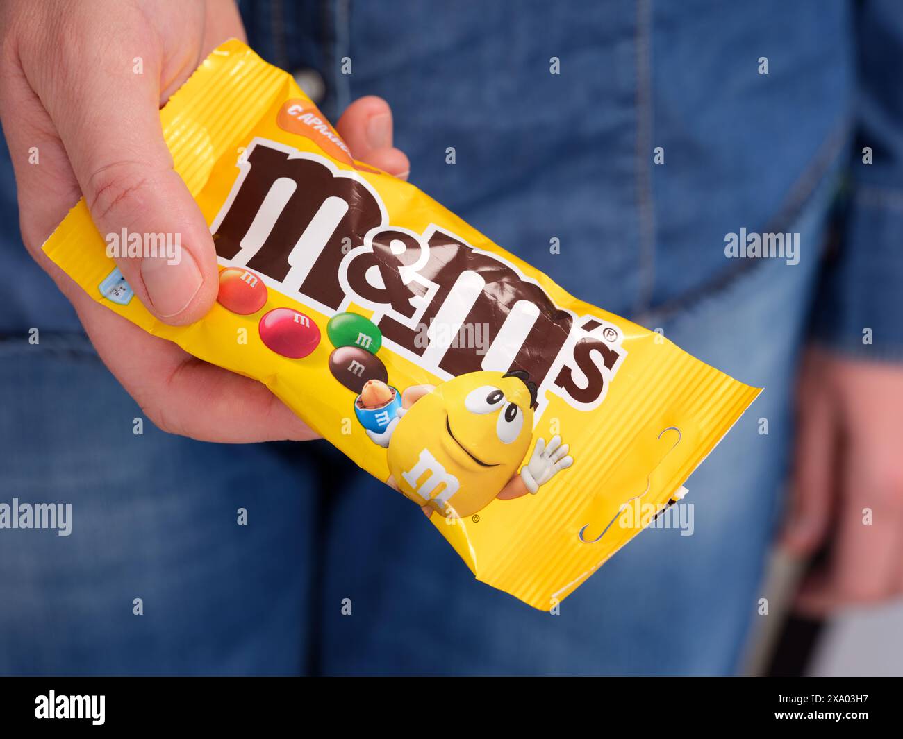 Tambov, Russian Federation - January 23, 2024 A woman holding out M&Ms ...
