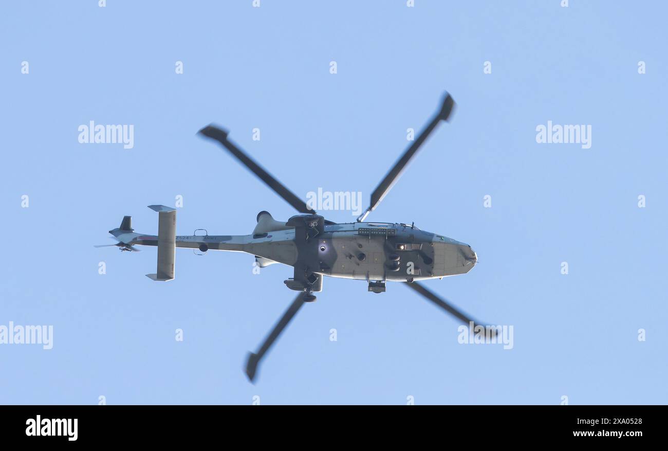 A helicopter with visible propeller blades cruises through the sky ...
