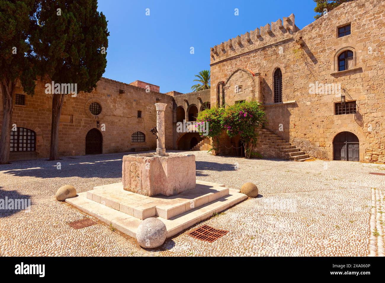 Panoramic view of medieval courtyard with stone buildings and a column ...