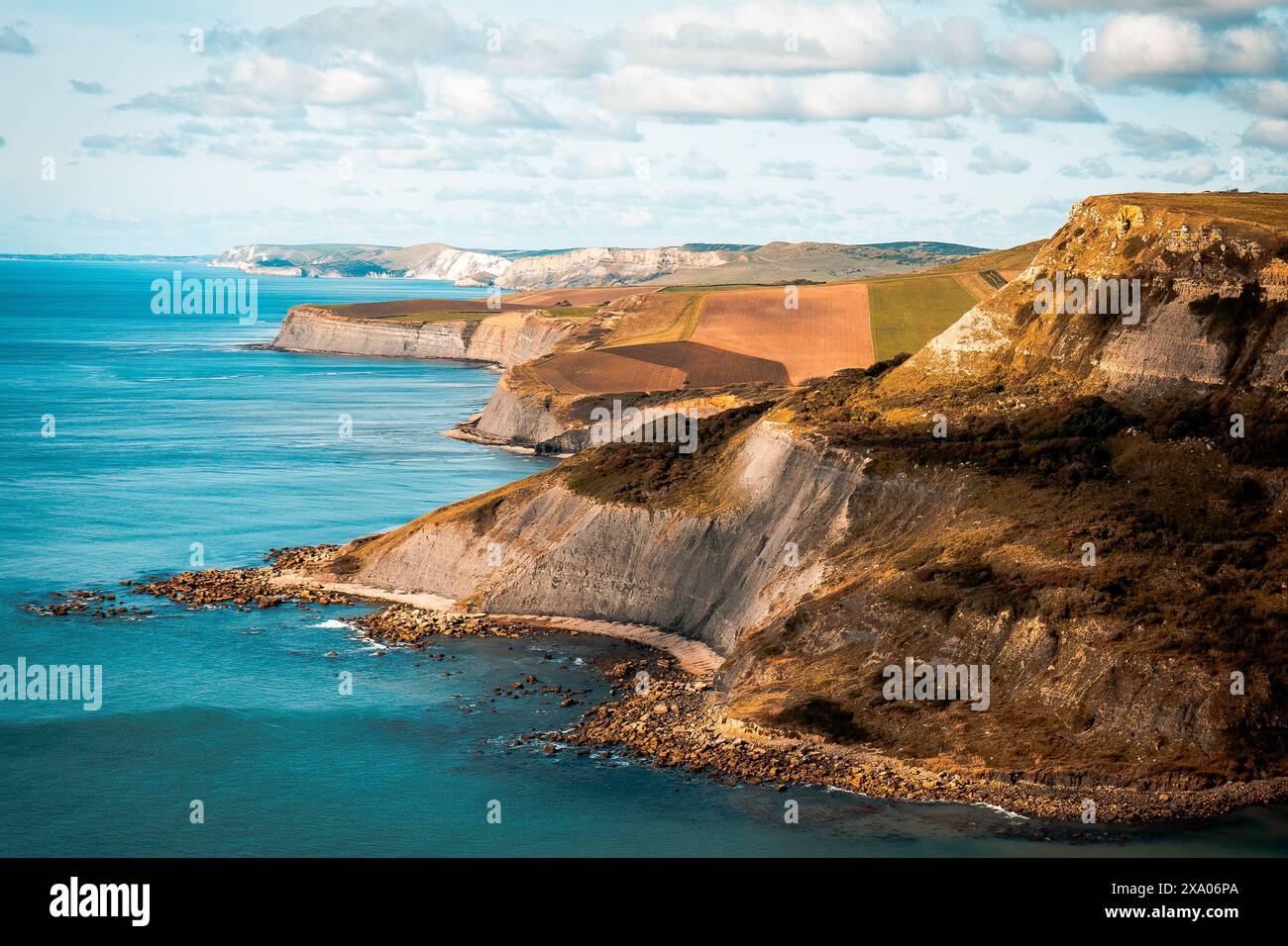 A vast body of water with a towering cliff in the Jurassic coast in ...