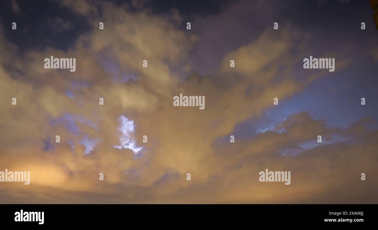 Orange stormy sky illuminated by the city streetlights at night and ...