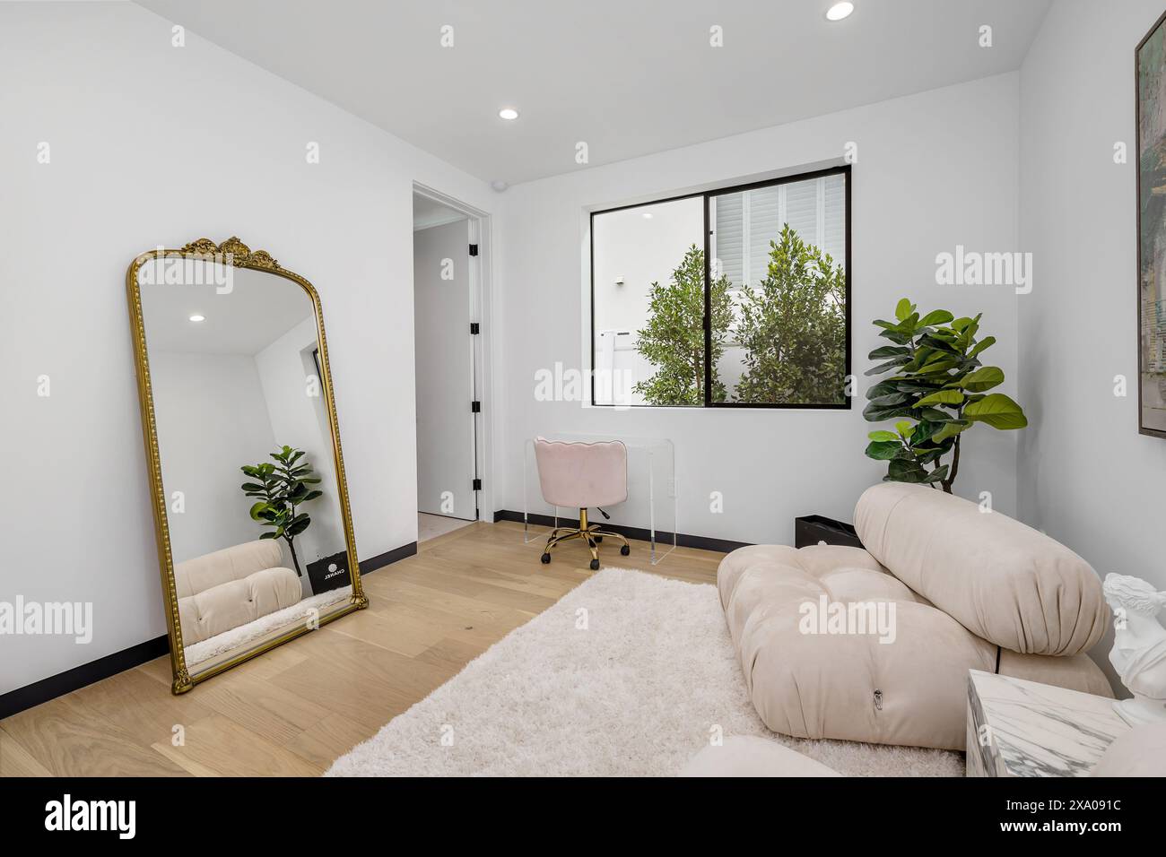 Spacious living room with a corner mirror and assorted decor items ...