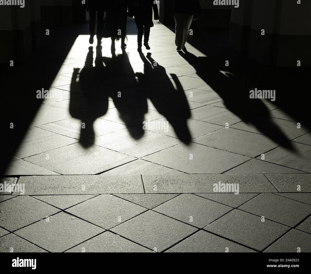 Shadows and silhouettes of people at a city during sunset Stock Photo ...