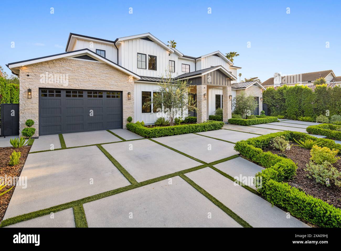 A well-maintained home with a garage featuring doors Stock Photo - Alamy