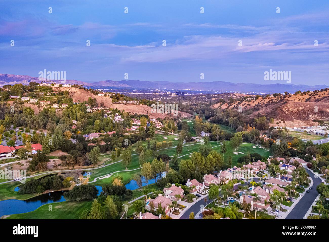 A sunrise view of a desert golf course surrounded by trees Stock Photo ...