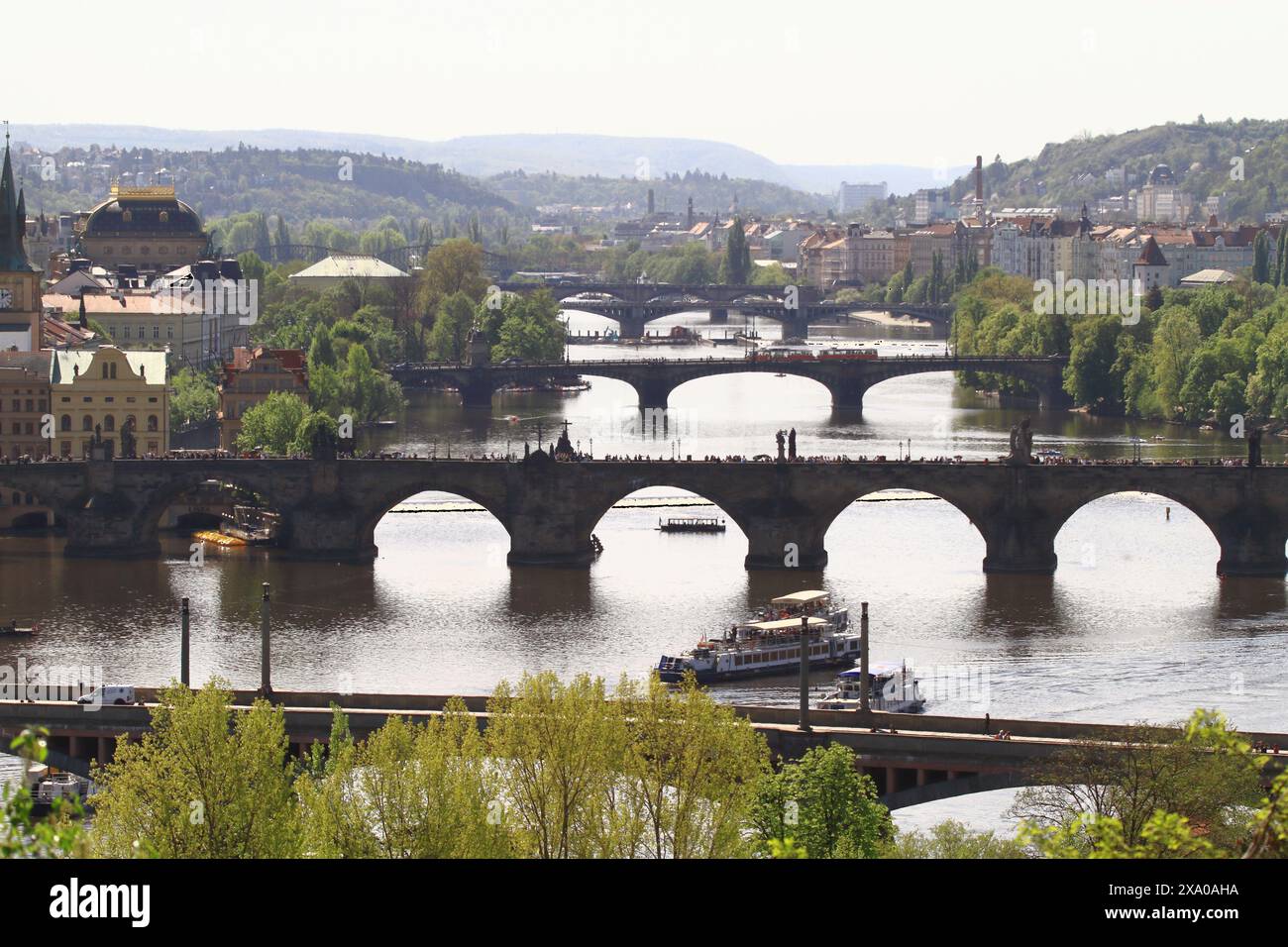 Multiple boats in the water with town and bridge in the background ...