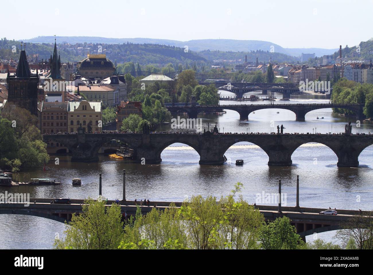 Multiple bridges over water surrounded by buildings, hills, and trees ...