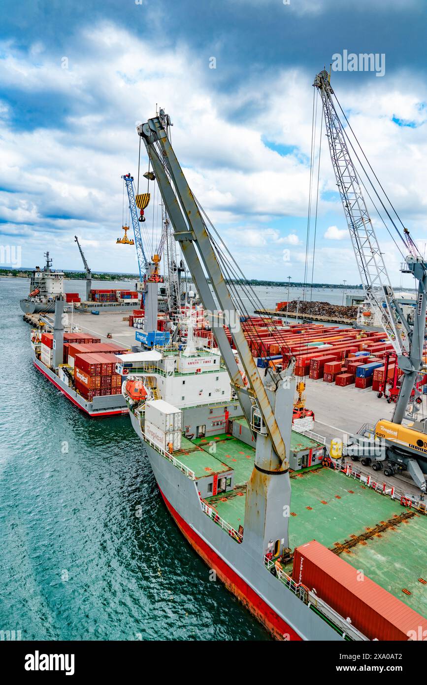 A massive cargo ship docked beside a large bridge Stock Photo - Alamy