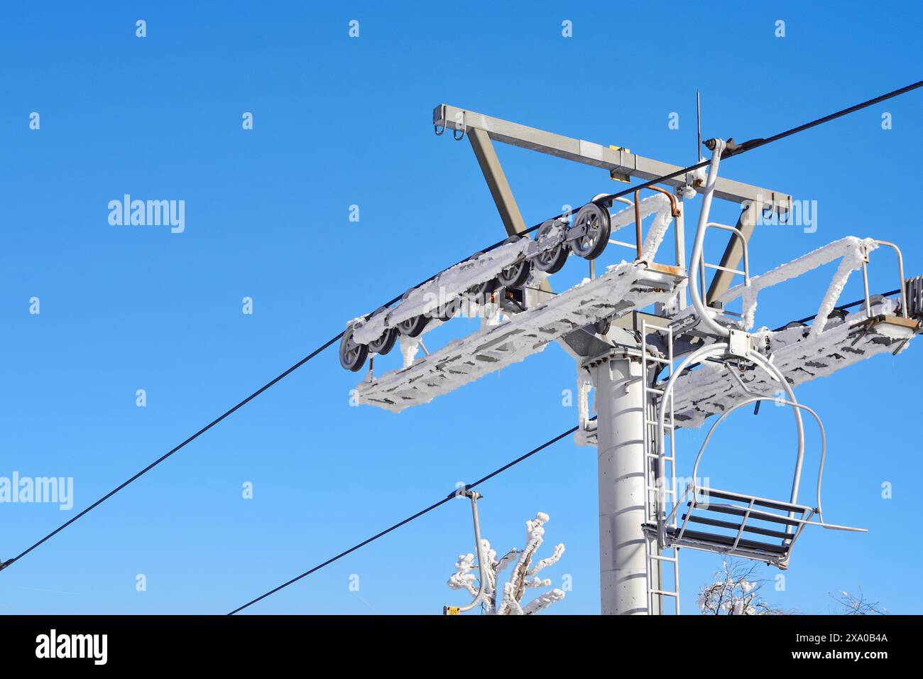 Detail view of a ski lift pole with many rolls and steel cables. Ski ...