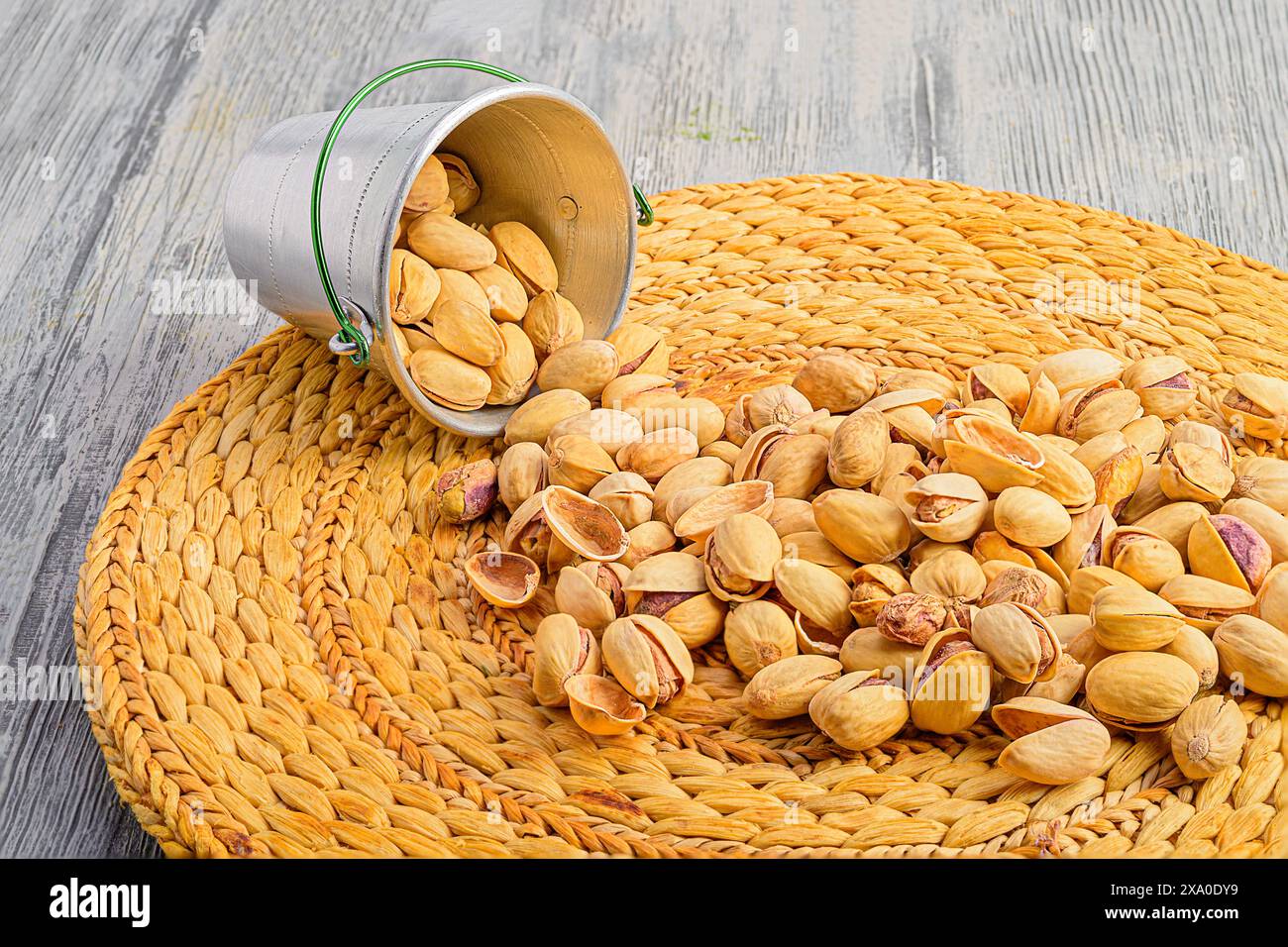 A Metallic cube full of pistachios on rustic esparto Stock Photo - Alamy
