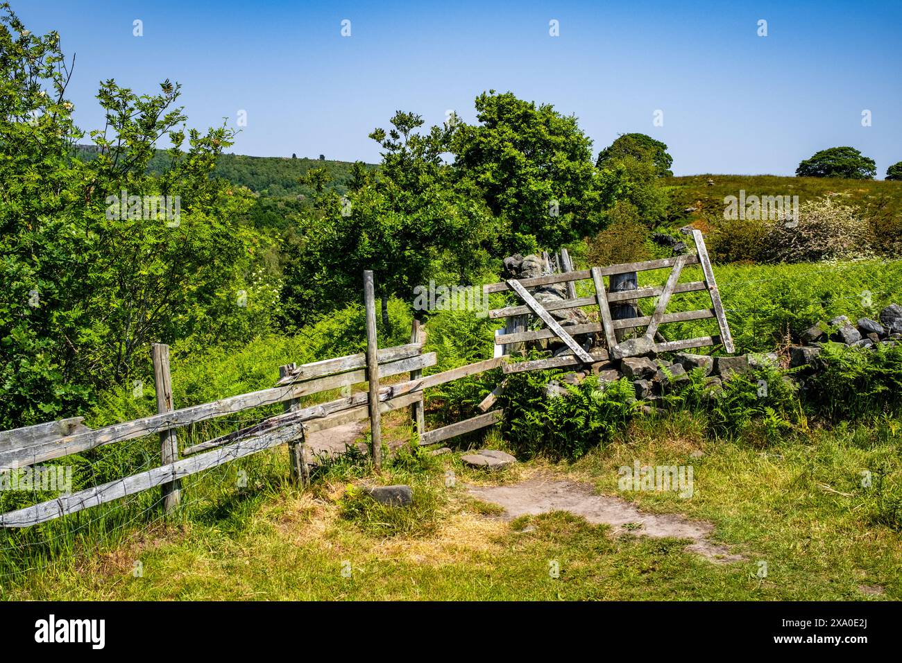 An old wooden stile gate in the country park summer time blue sky in ...