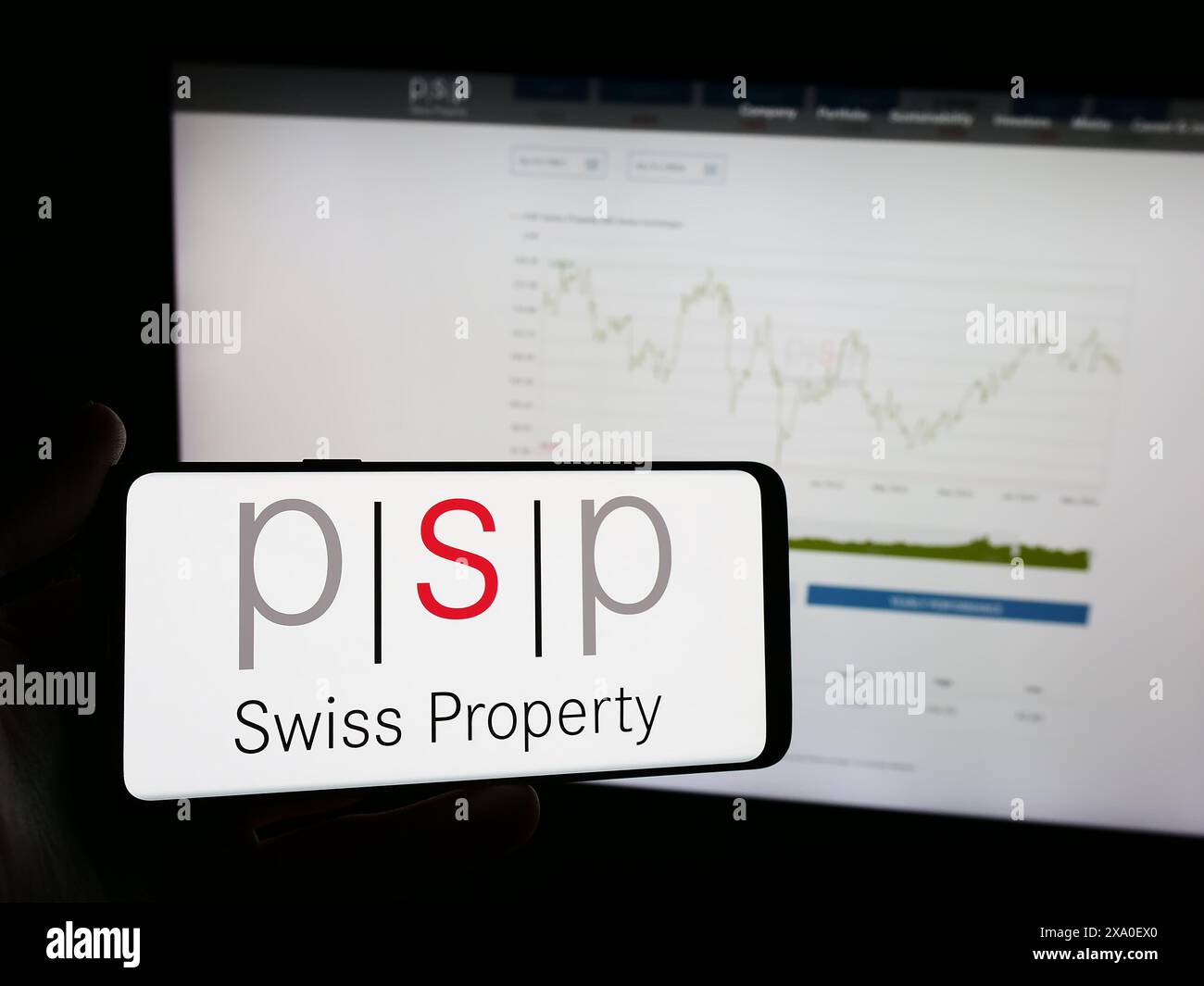 Person holding mobile phone with logo of real estate company PSP Swiss ...