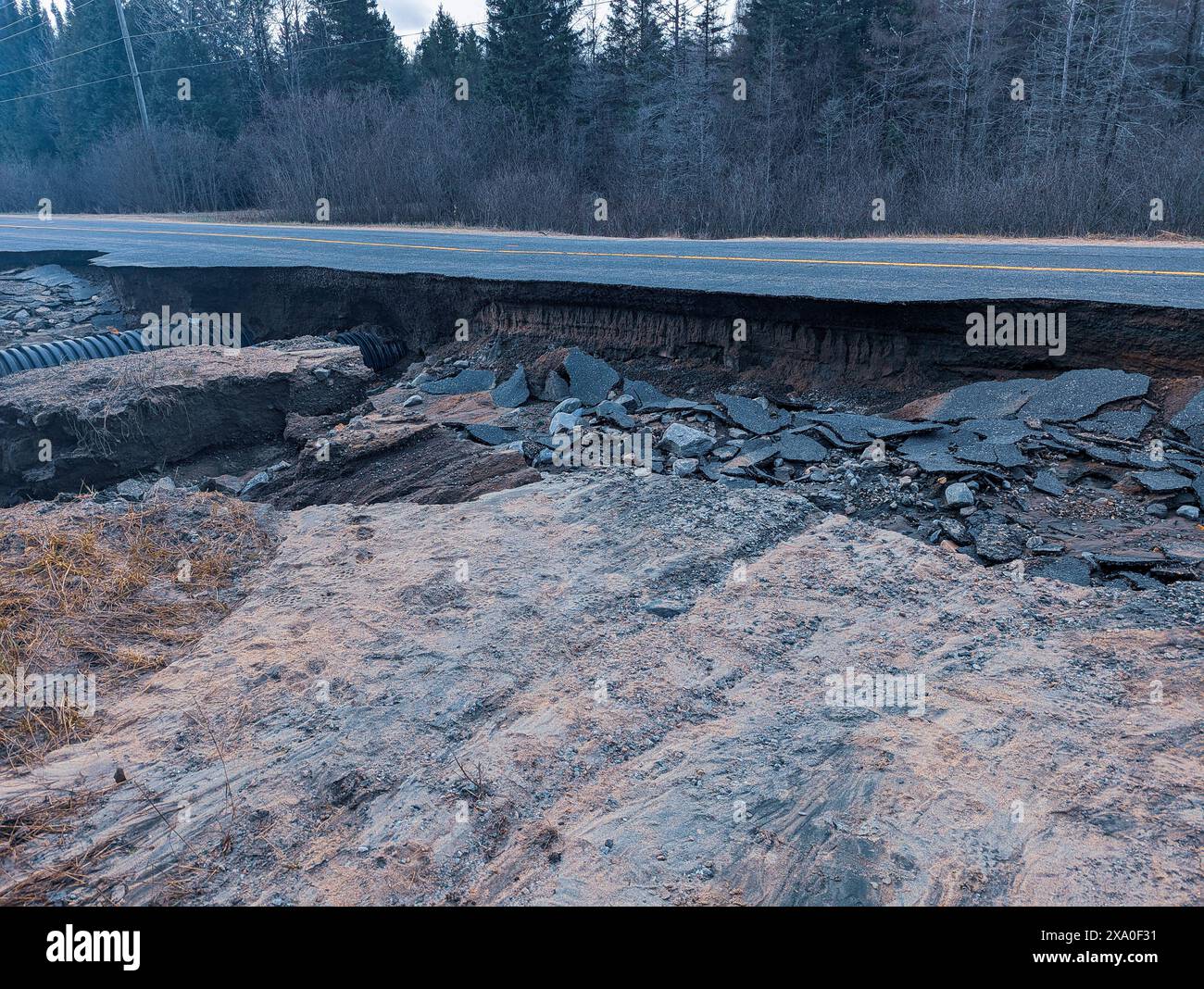 A damaged highway from a broken beaver dam, Road washout Stock Photo ...