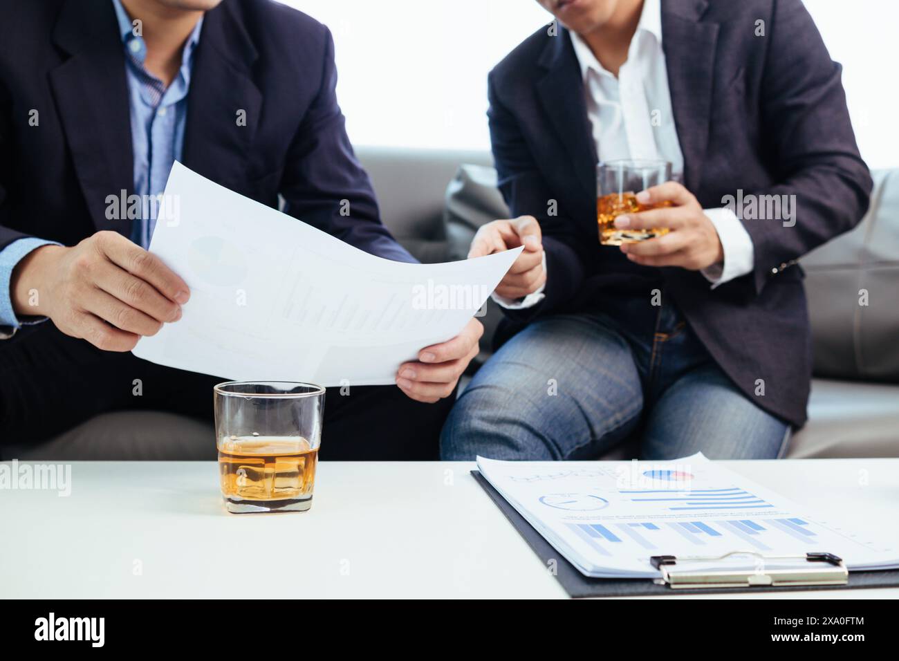 Businessmen and investors drink alcohol together in office after ...