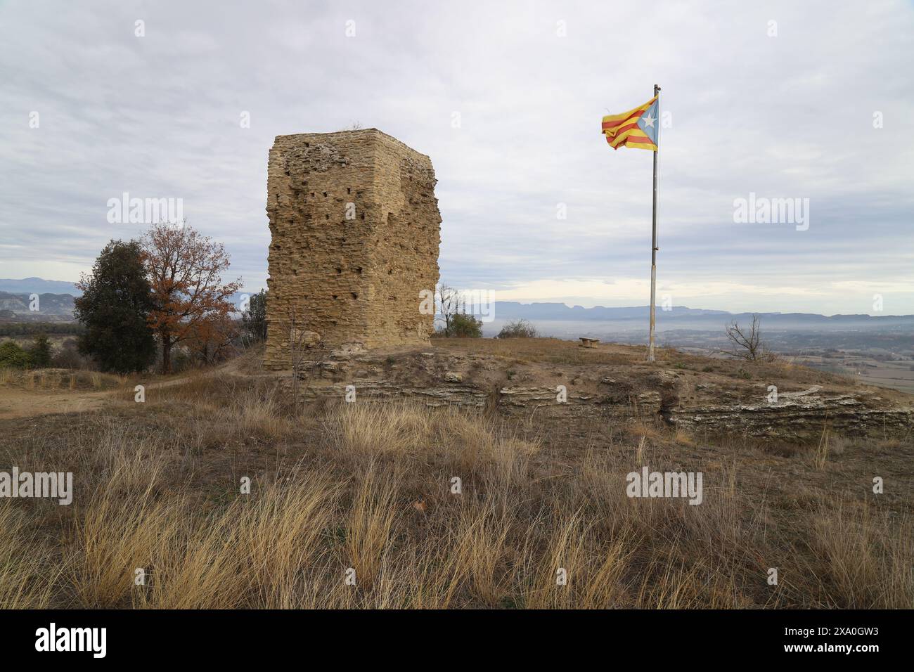The flag of Barcelona near an ancient stone structure. Tona's Castle ...