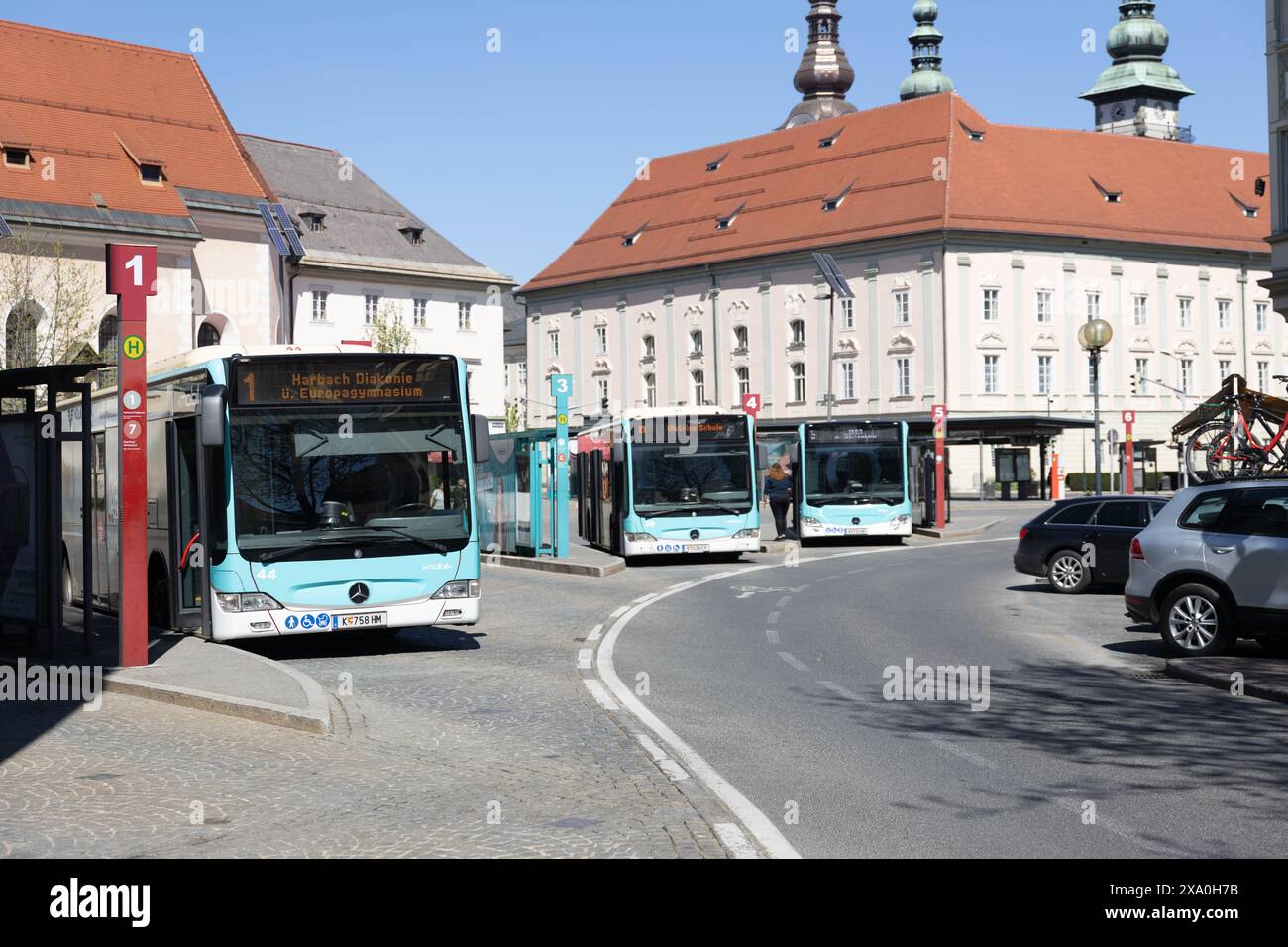 Multiple buses parked on a street with buildings on both sides Stock ...